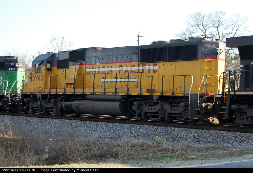 HLCX SD-60 #5945 is mid consist on this westbound crossing Rives Rd.